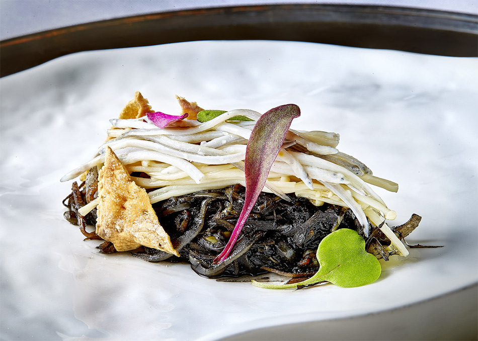 Txoko encebollado en su tinta con enoki, torta de quinoa y angulas de ...